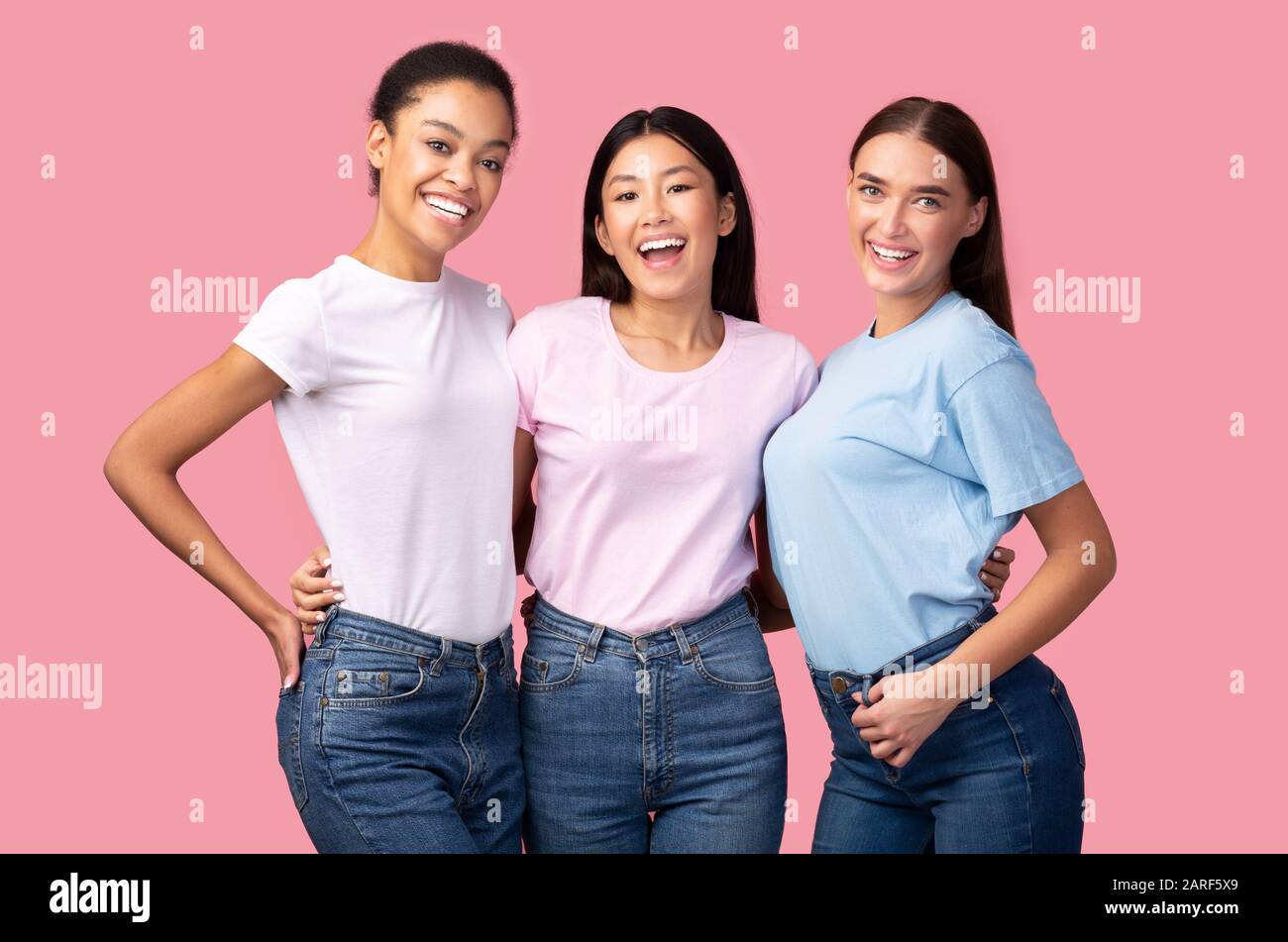 Three Joyful Women Hugging On Pink Background Stock Photo - Alamy