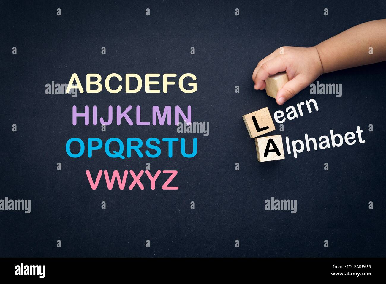 Learning Alphabet with words ABC, wooden cube and children hands on black background. Selective ...