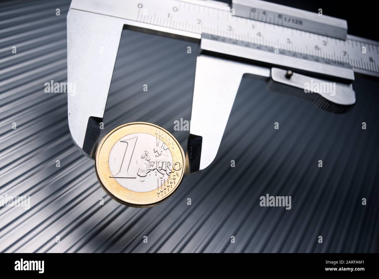 metal gauge measuring a one euro coin on a metal surface Stock Photo ...