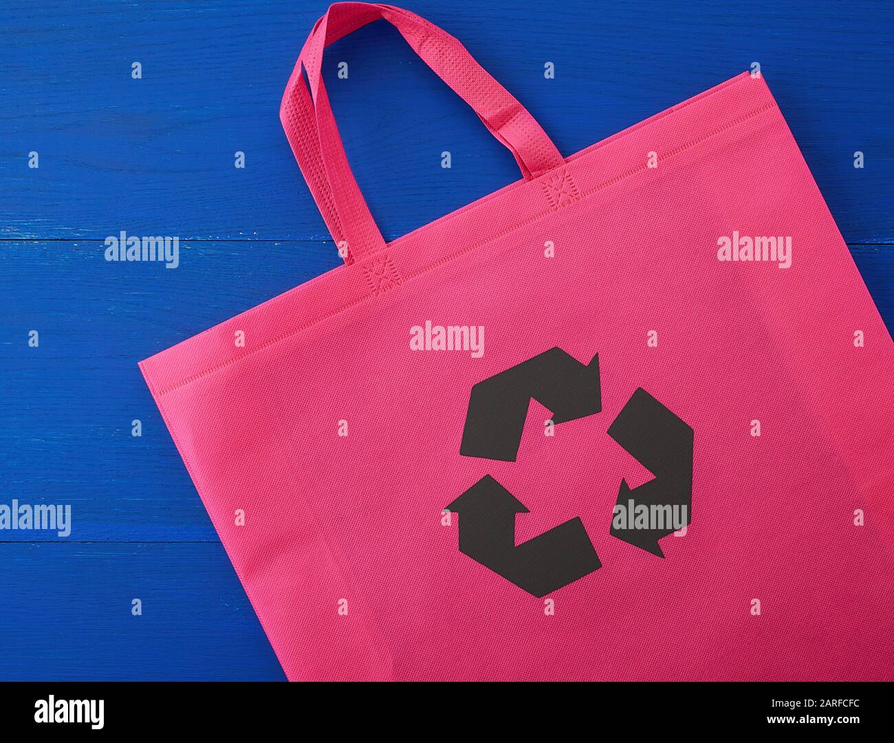 Reusable pink viscose bag on blue wooden background, plastic waste ...