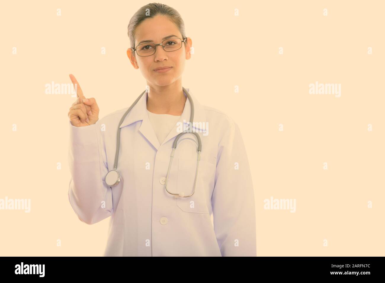 Studio shot of young beautiful woman doctor pointing finger up Stock ...