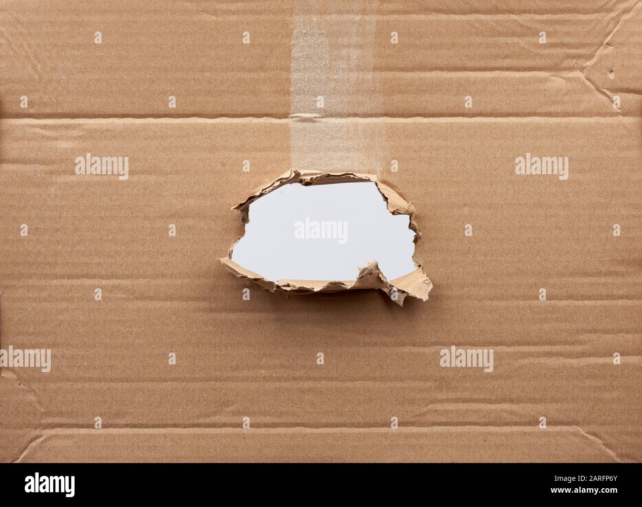 hole in brown cardboard paper with torn and curved edges. Blank ...