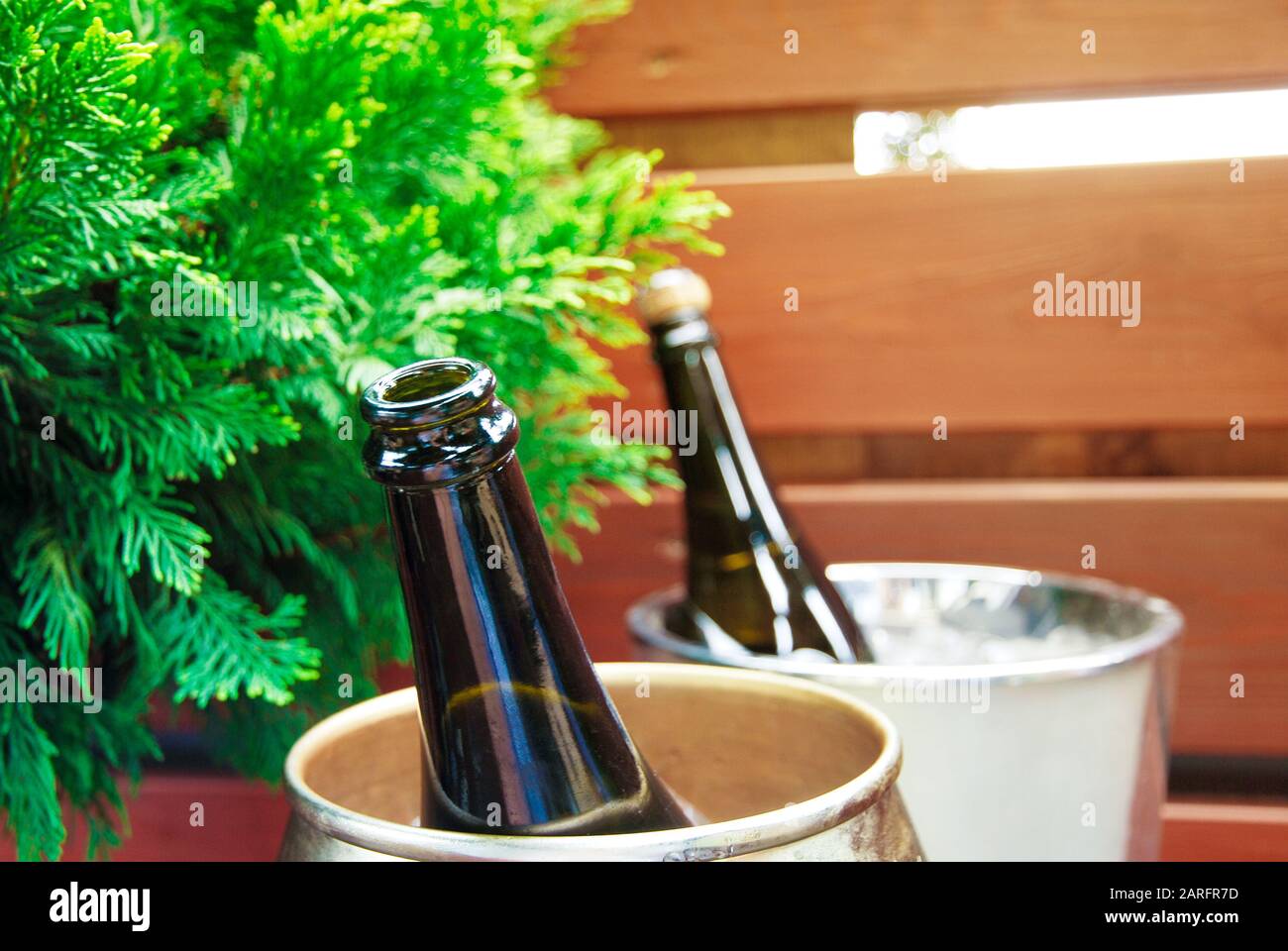 Open and closed bottles of champagne in ice buckets Stock Photo - Alamy
