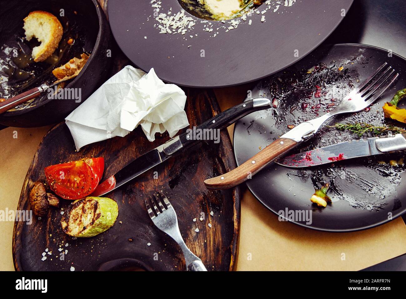 Black table with leftover food after dinner Stock Photo - Alamy