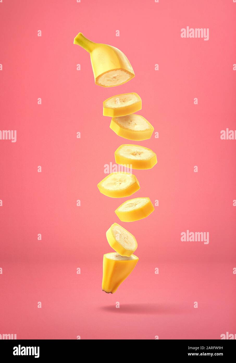 Flying fresh ripe banana cut into slices on pink background Stock Photo ...