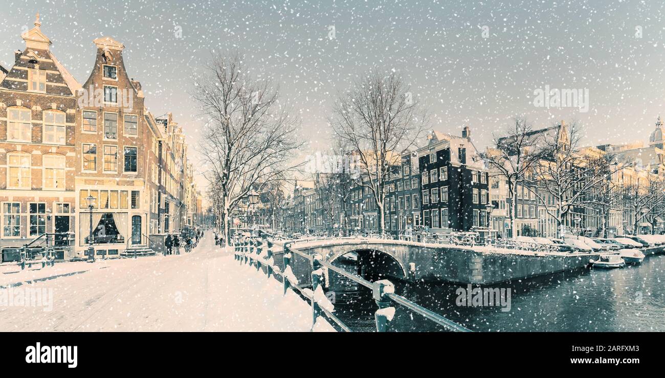 Winter snow view of Dutch canal and old houses in the historic city of ...