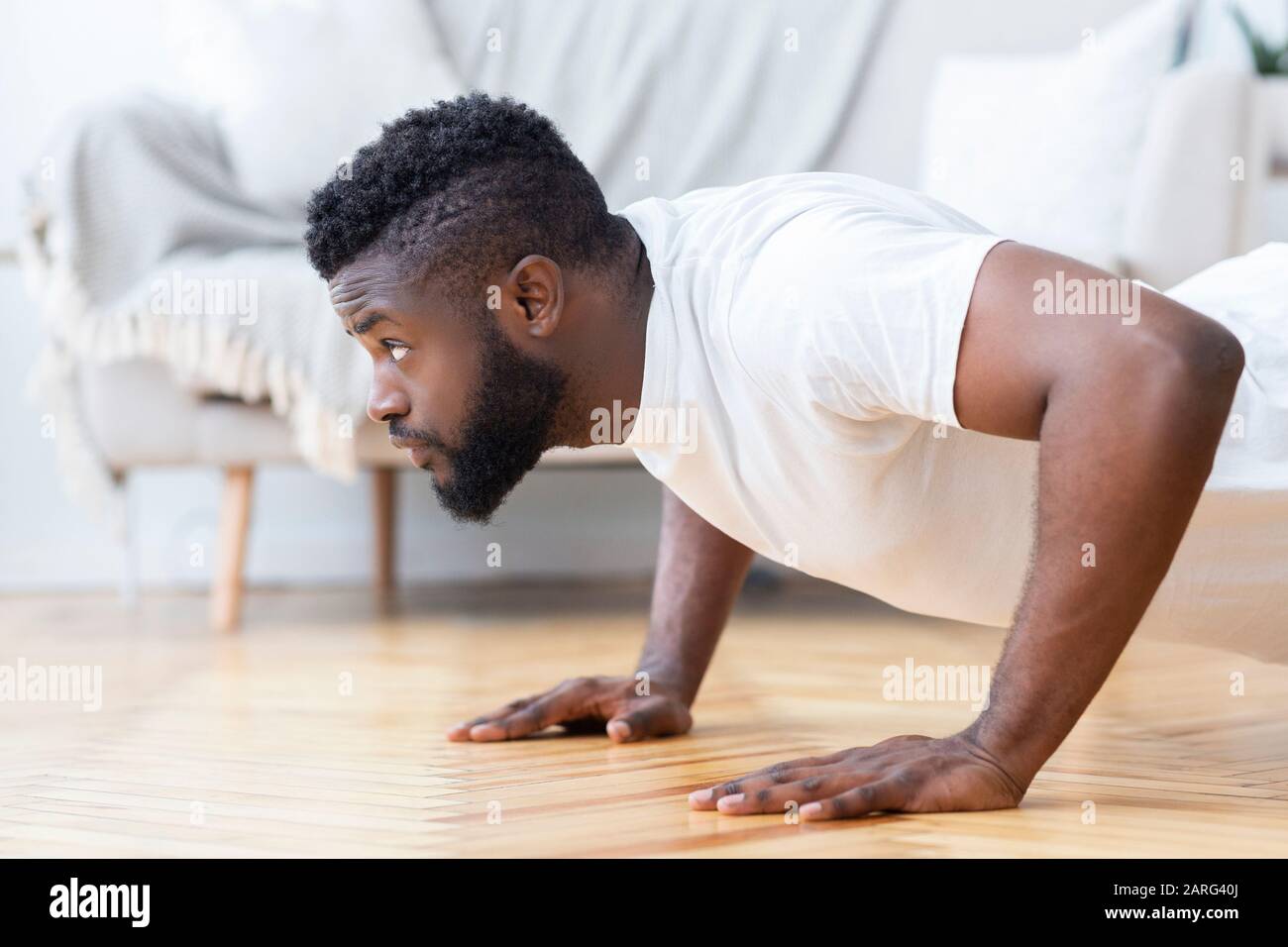Young black man doing push ups, side view Stock Photo - Alamy