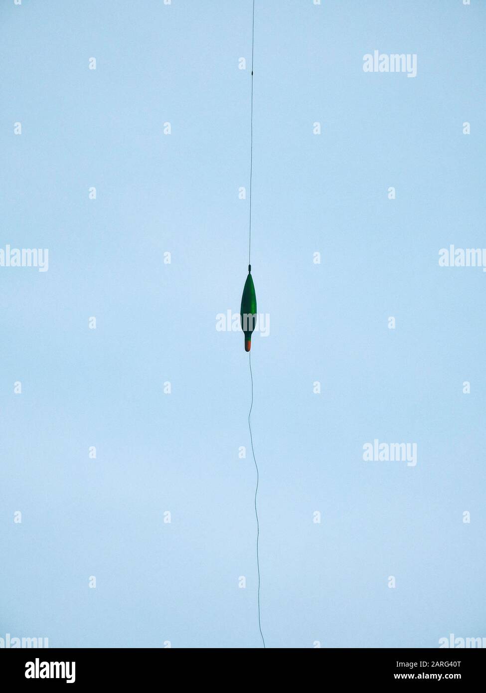 Fishing blinker in the air in front of blue sky Stock Photo - Alamy
