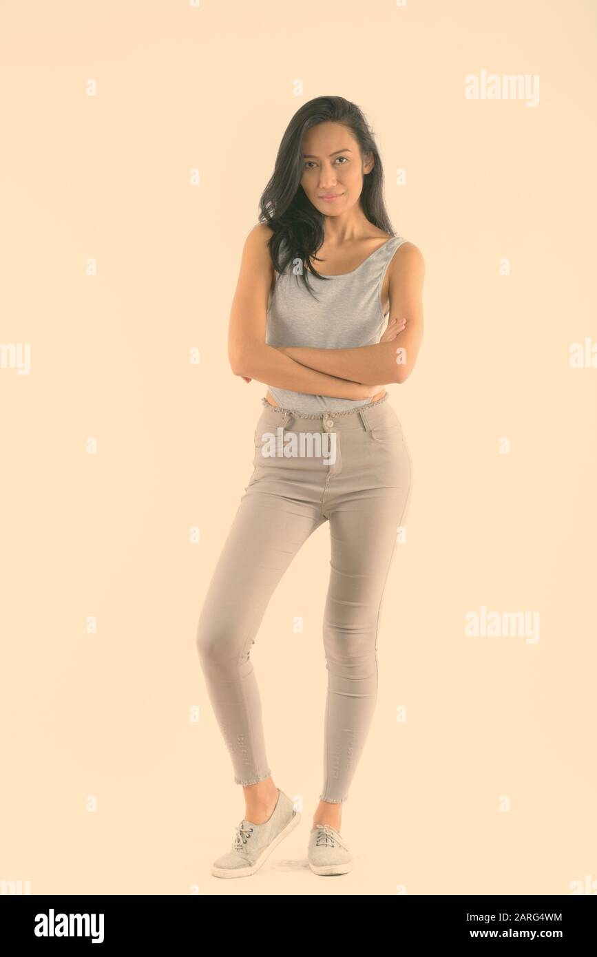 Full body shot of young beautiful Asian woman posing with arms crossed ...