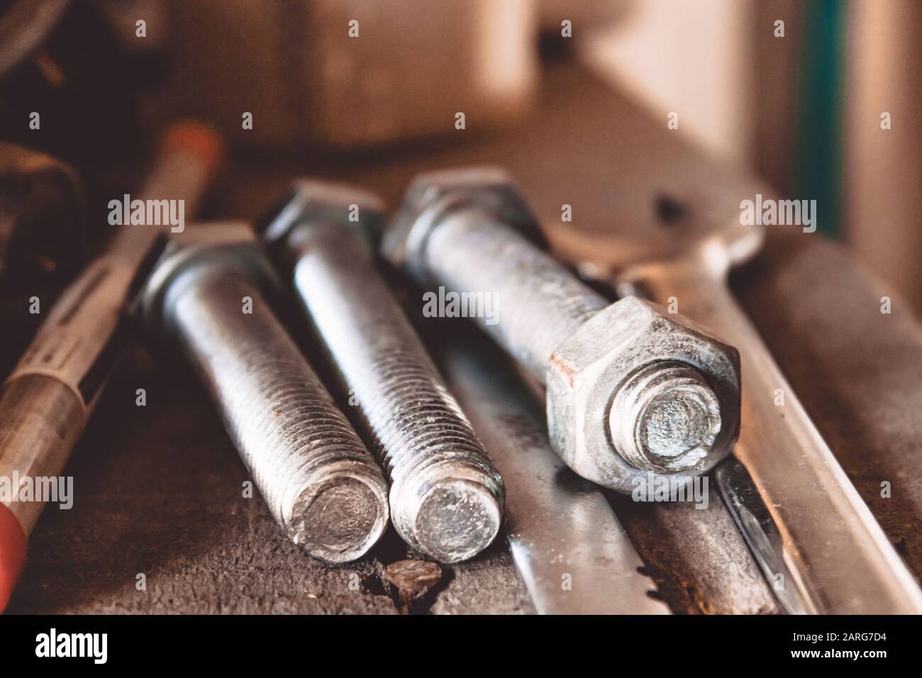 Tools for the job. Bolts and nut with wrench are on the table. Various ...