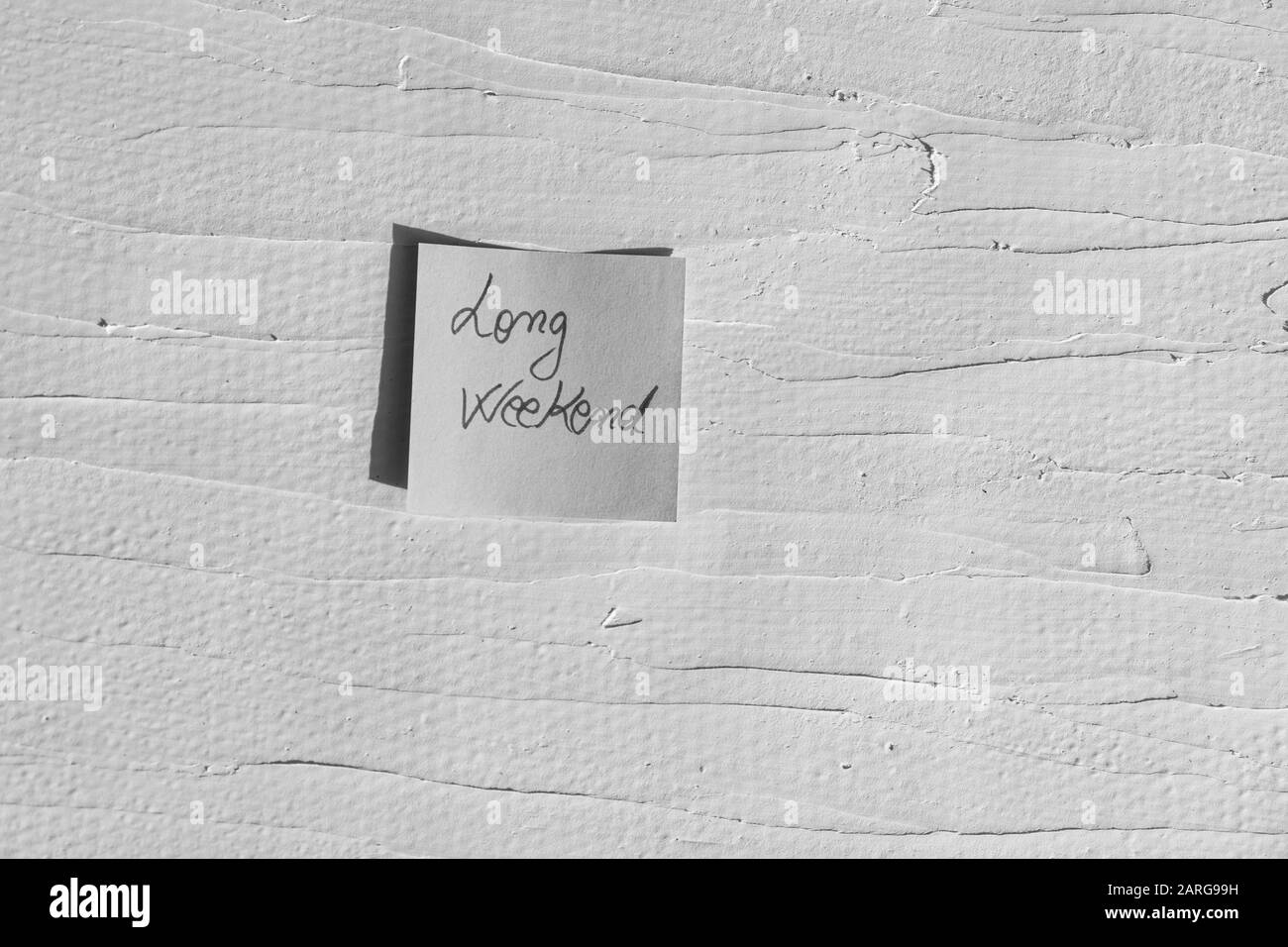 Handwriting text on memo post reminder. Long weekend on paper, on white ...