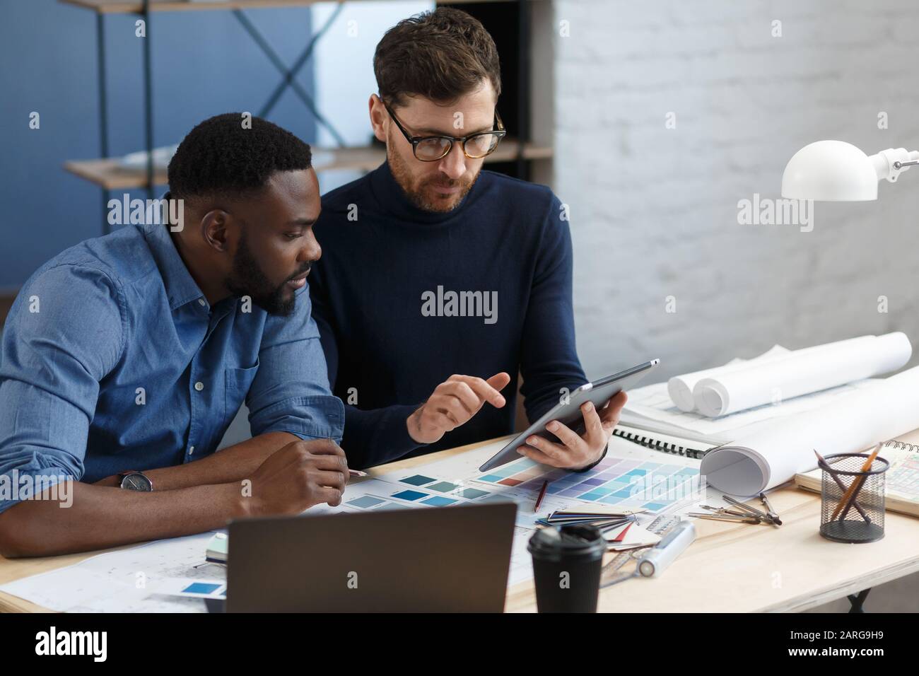 Multiracial engineer team working in office with tablet PC. Architects ...