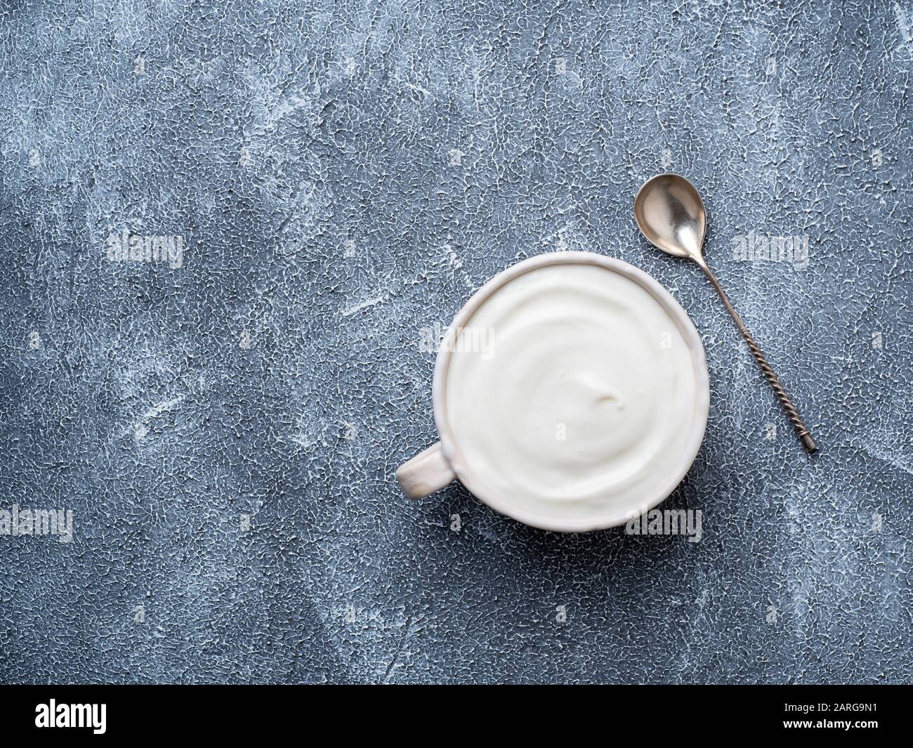 Greek yogurt in white bowl on grey blue concrete stone table, top view ...