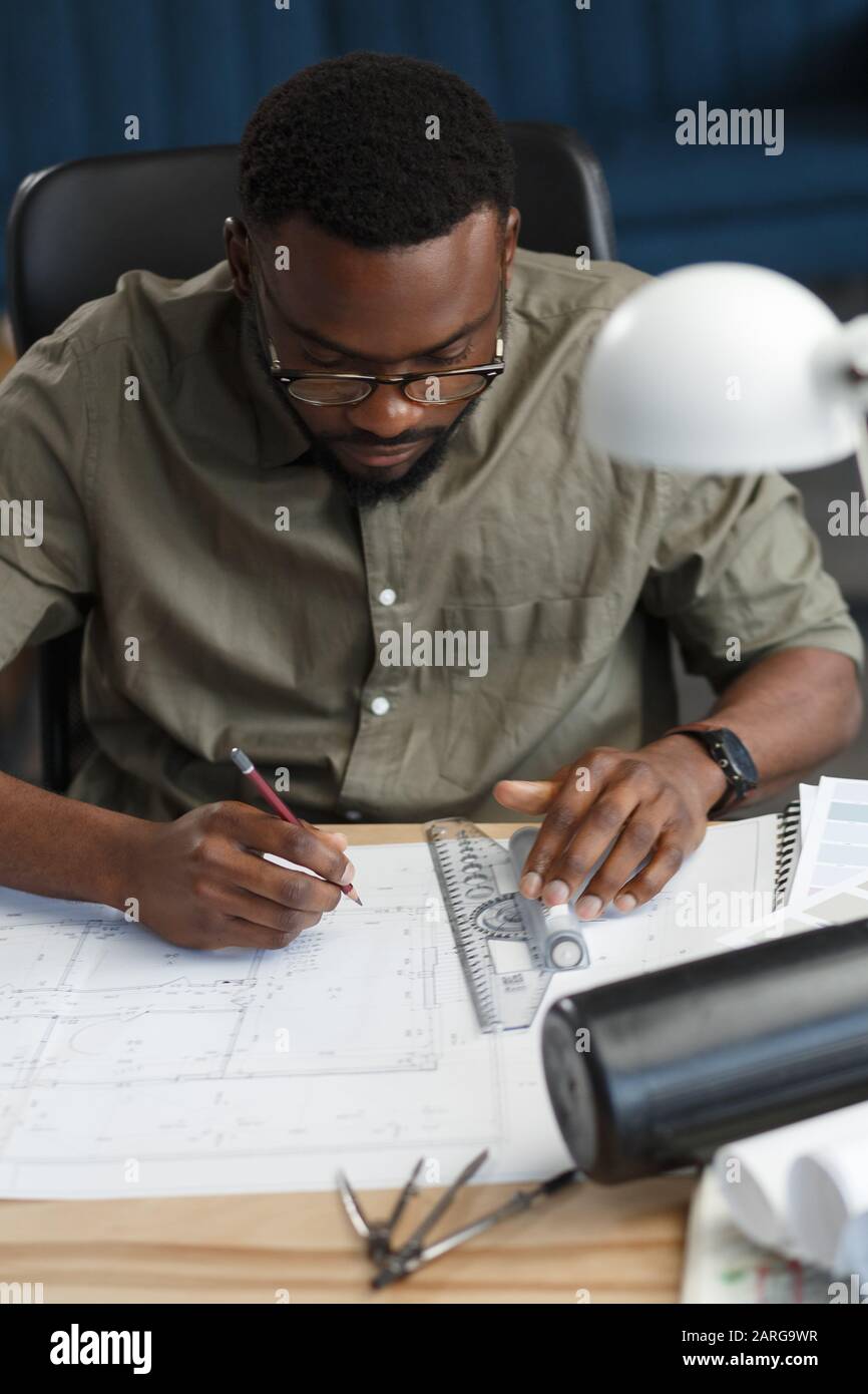 Afro-American architect working in office with blueprints.Engineer ...