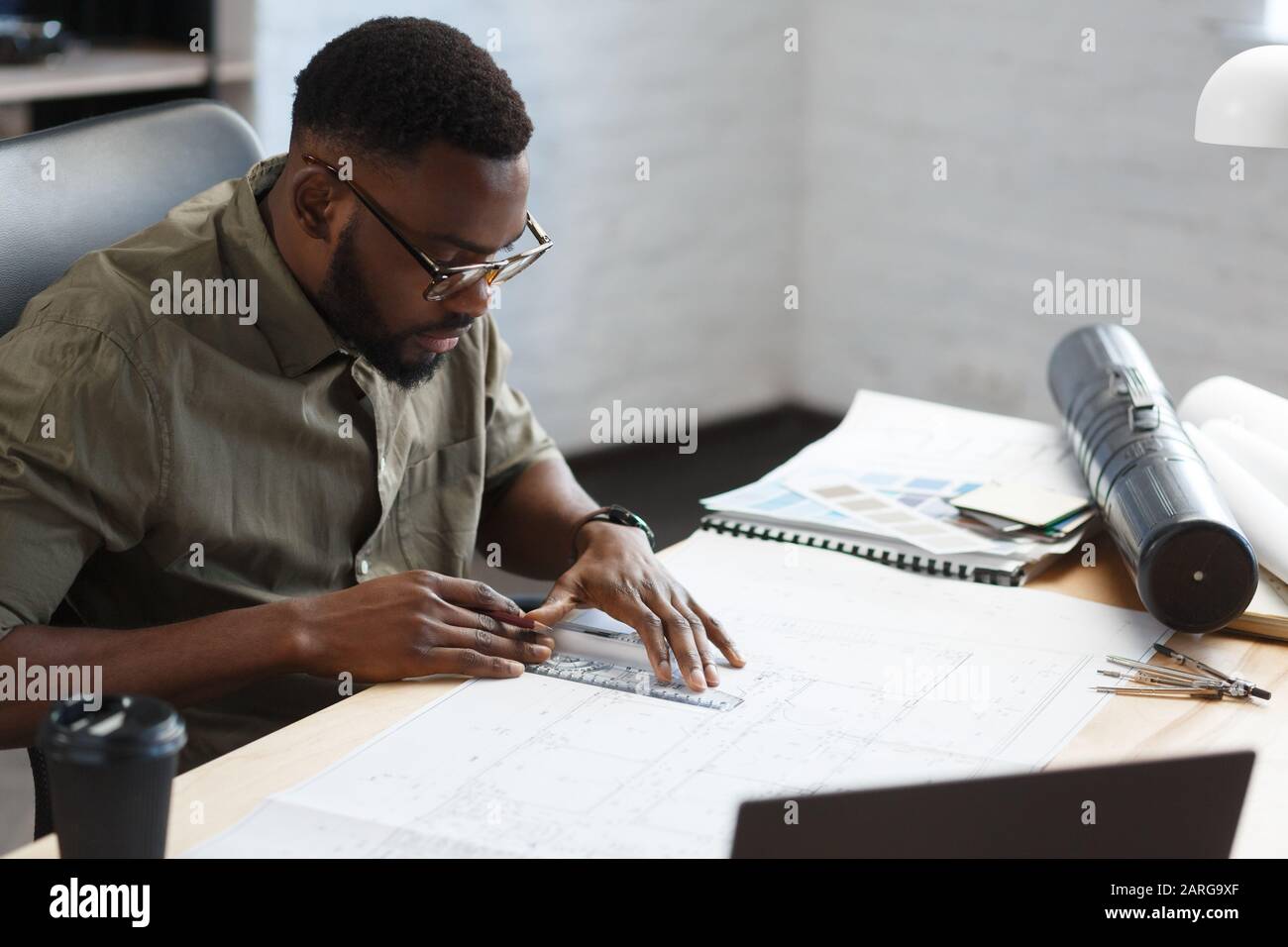 Afro-American architect working in office with blueprints.Engineer ...