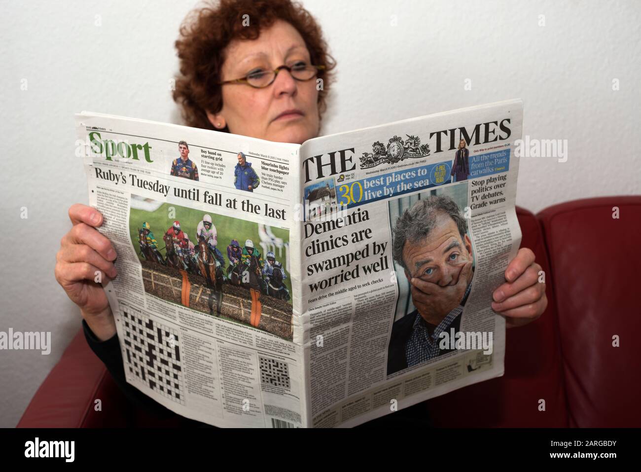 Woman Reading A Copy Of The Times Newspaper High Resolution Stock ...