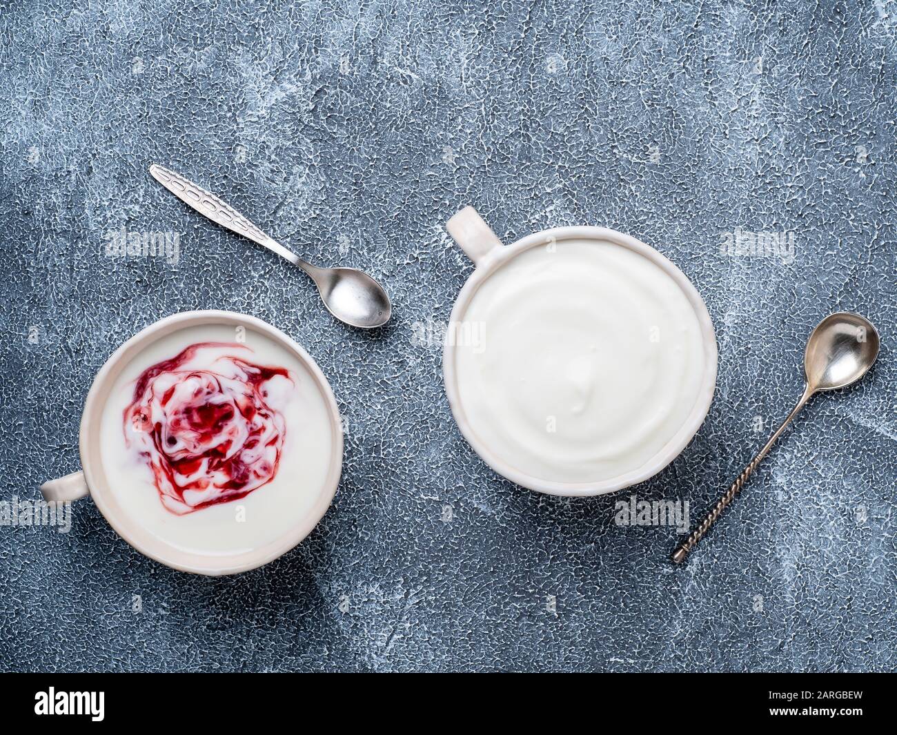 Two greek yogurt in white bowl on grey blue concrete stone table, top ...