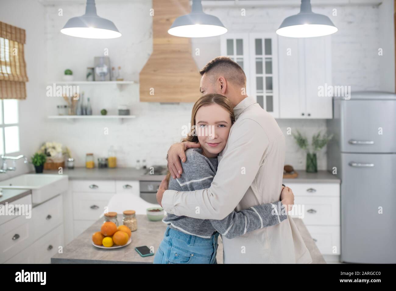 Happy dad and daughter hugging in the kitchen Stock Photo - Alamy