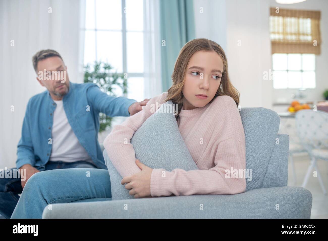 Sad daughter turned away from her father Stock Photo - Alamy