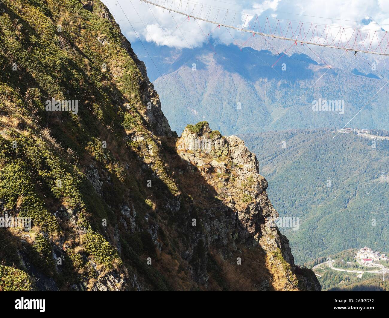 View of a steep cliff near with a suspension bridge over mountain abyss ...