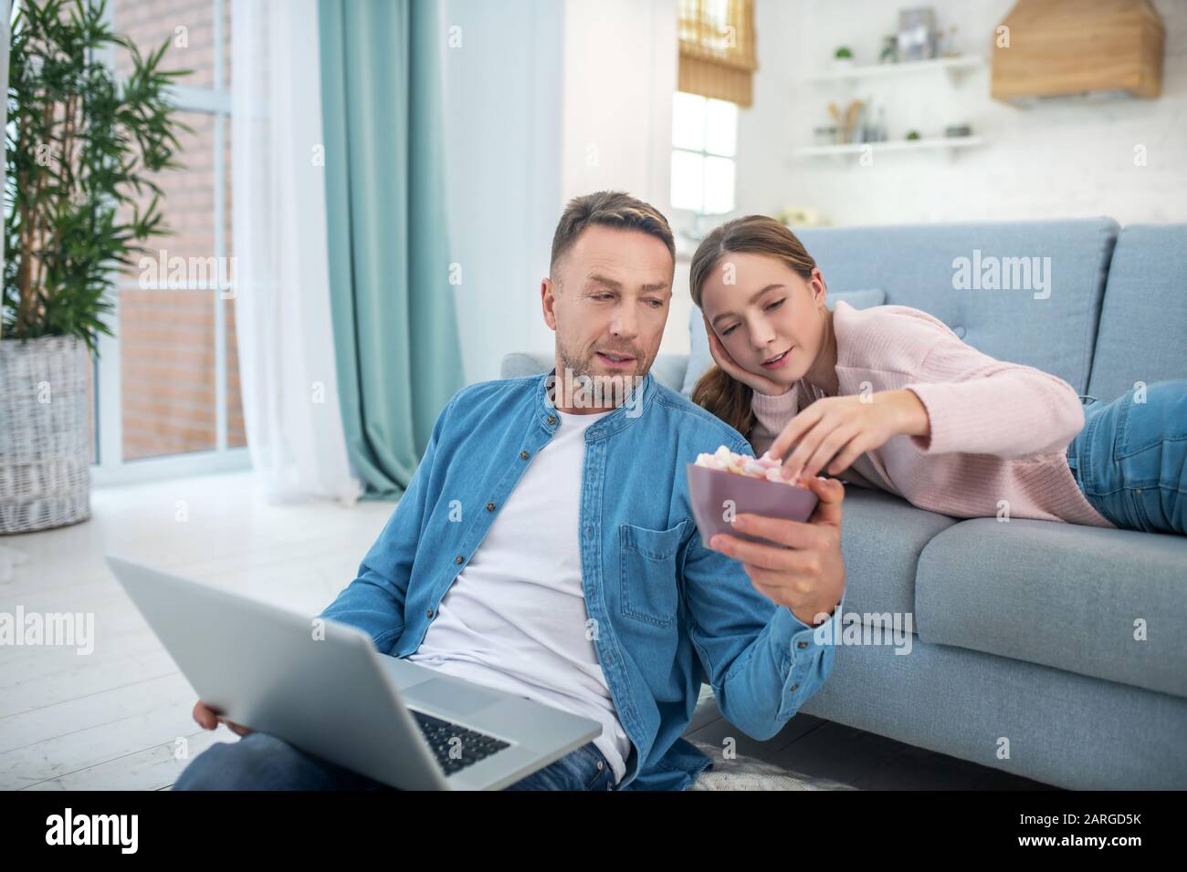 Dad with a laptop giving a marshmallow to his daughter Stock Photo - Alamy