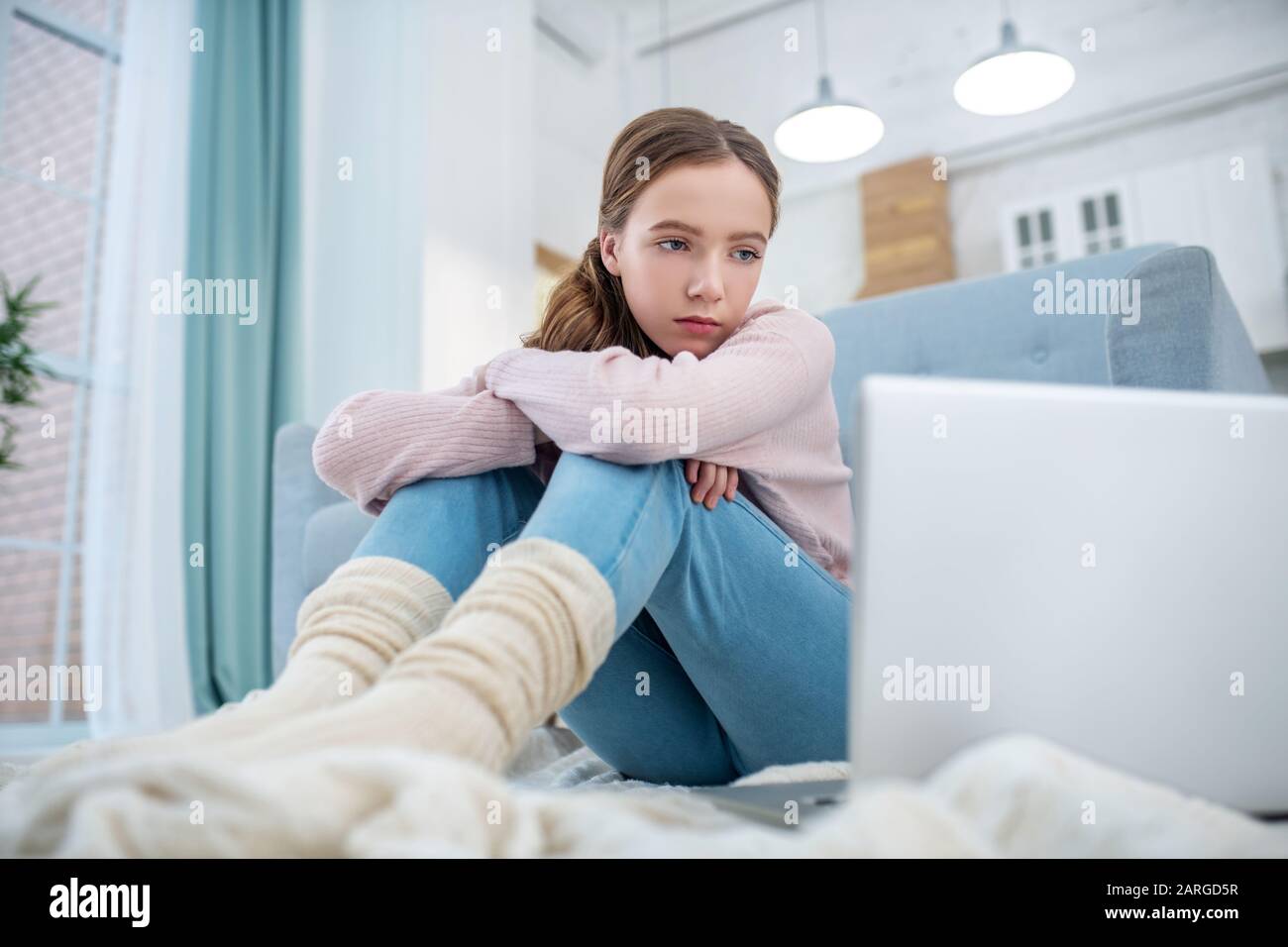Teen girl sitting on the floor looking at laptop screen Stock Photo - Alamy