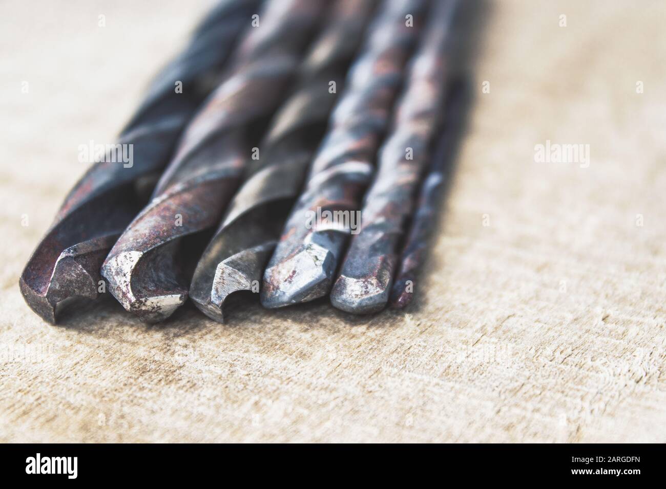 Drills on a wooden background. The concept of tools and repair work ...