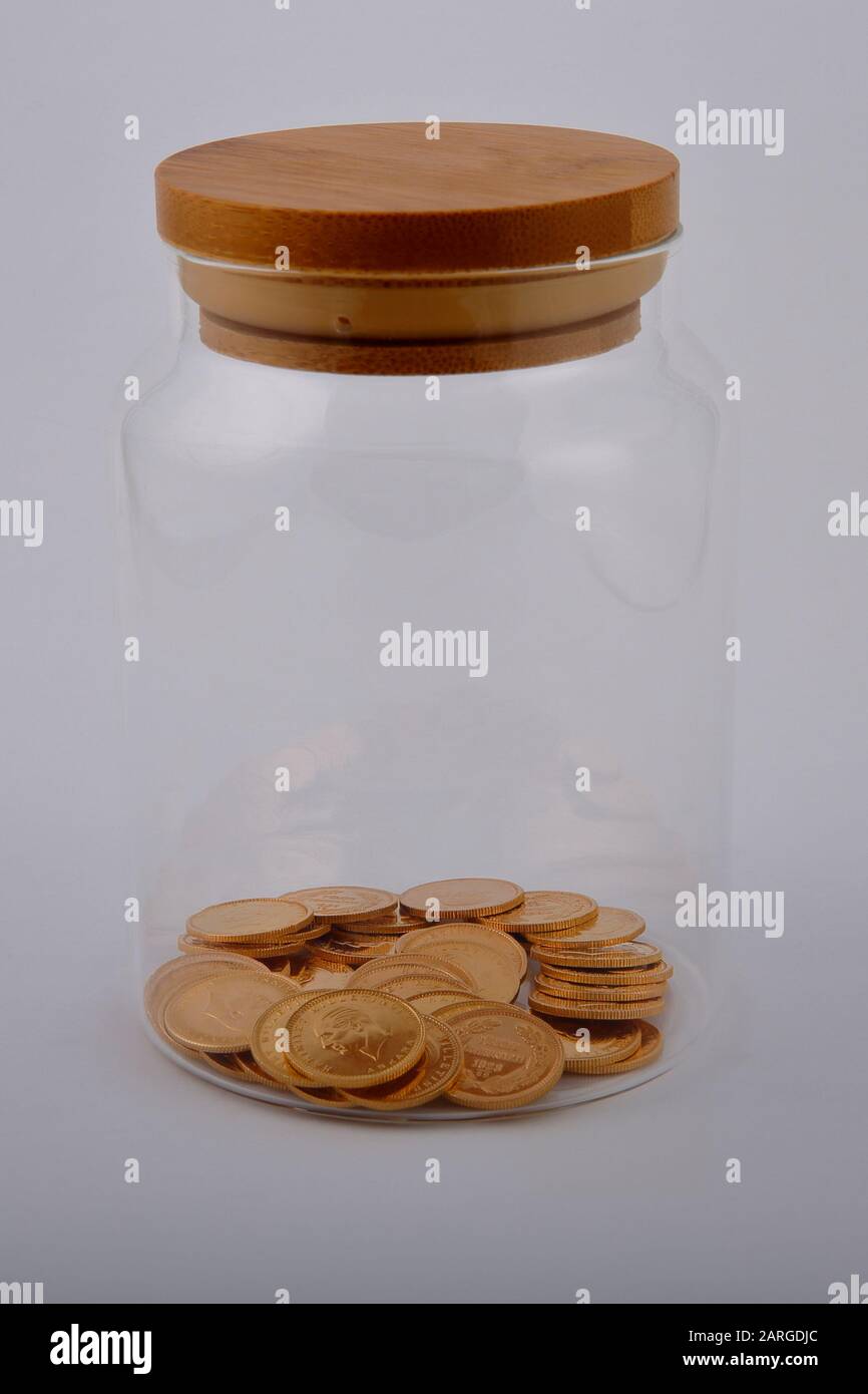 View of golden coins in jar, on white background Stock Photo - Alamy