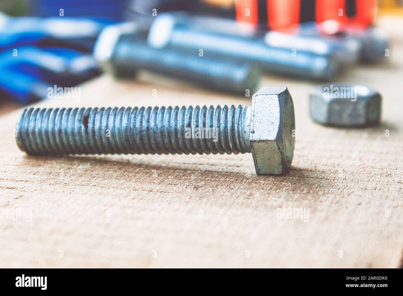 Steel nut bolt and washers lie on wooden boards. The concept of tools ...