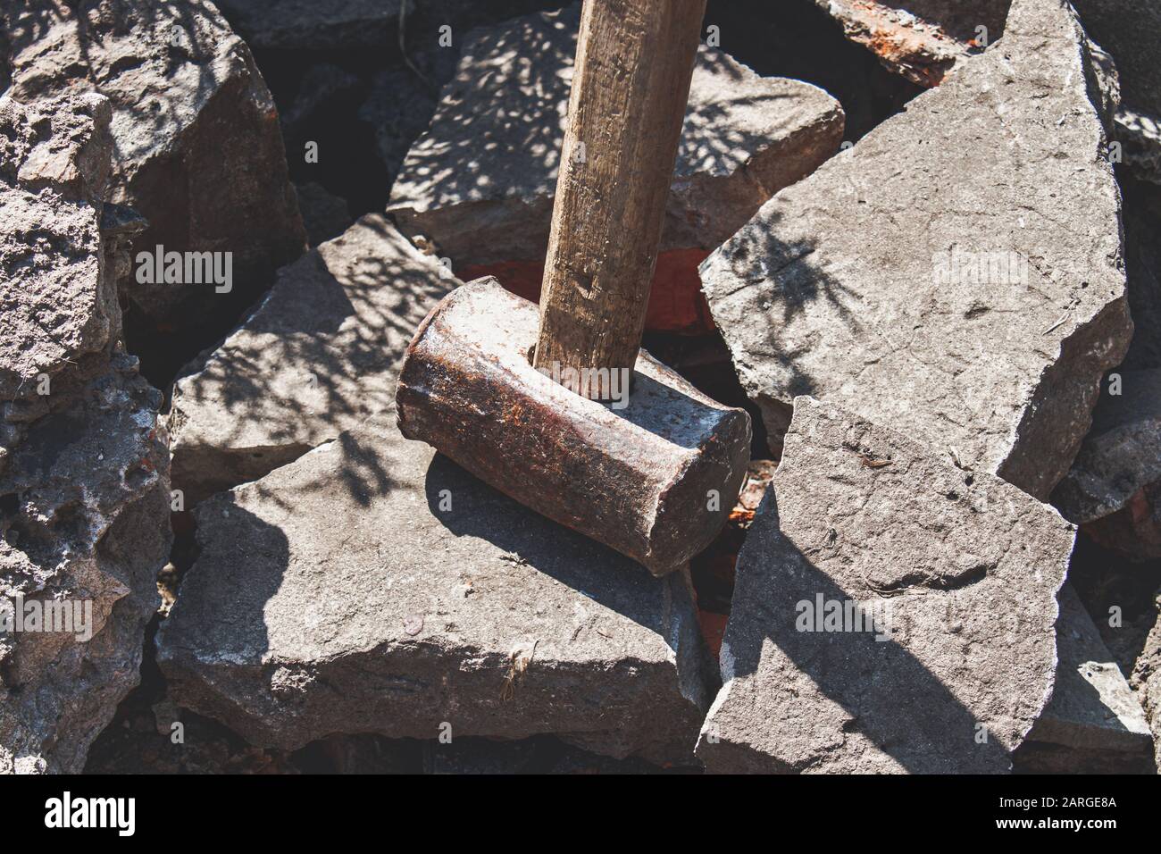 Rusty sledgehammer on broken bricks and concrete stones. Metal ...