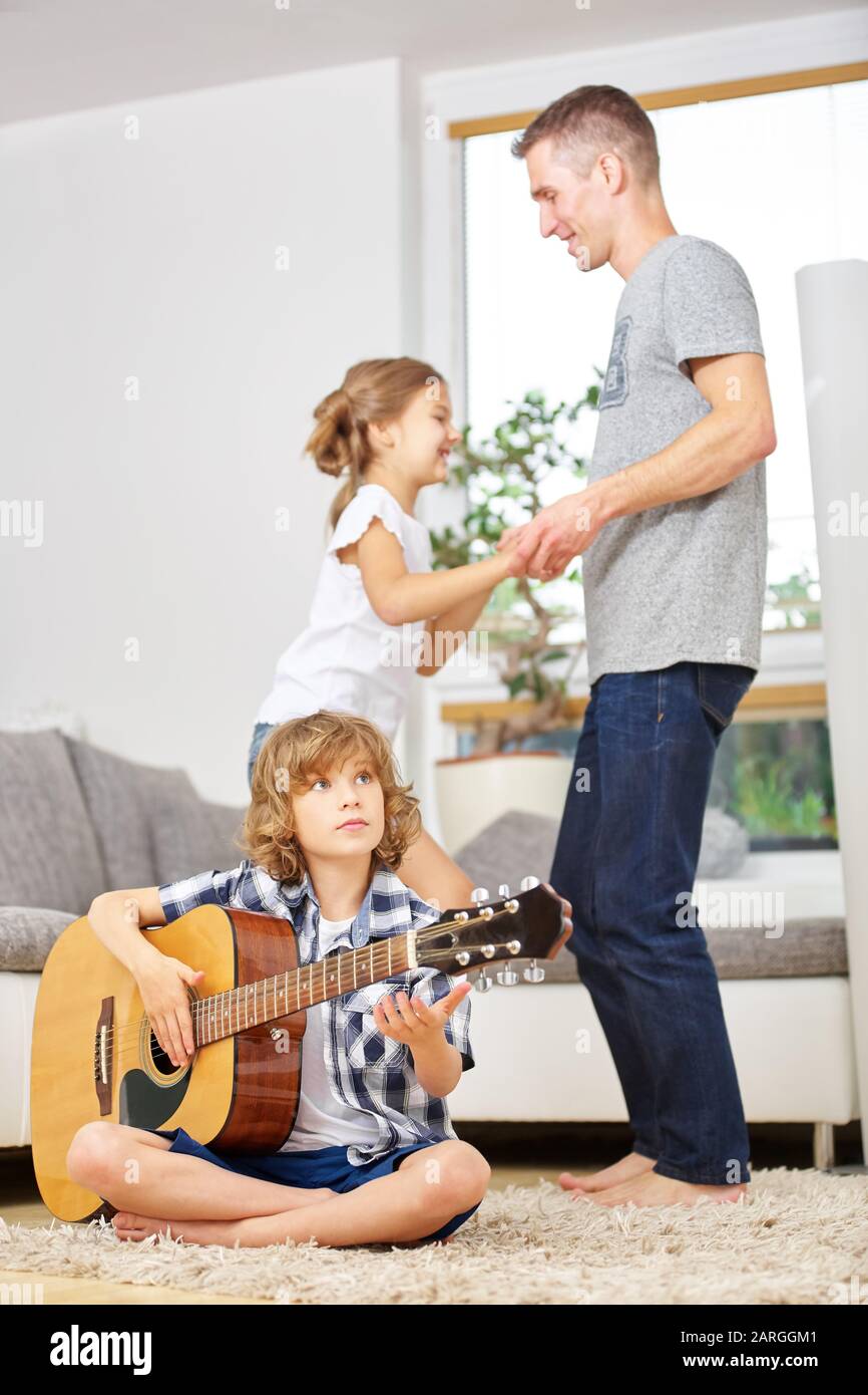 Family playing music with guitar and dancing Stock Photo - Alamy