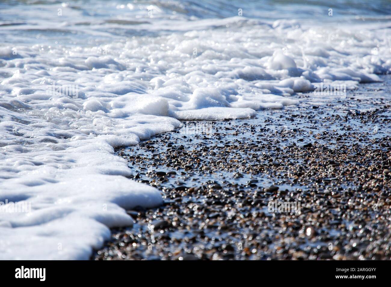 Sea foam wave and wet pebbles on the beach Stock Photo - Alamy
