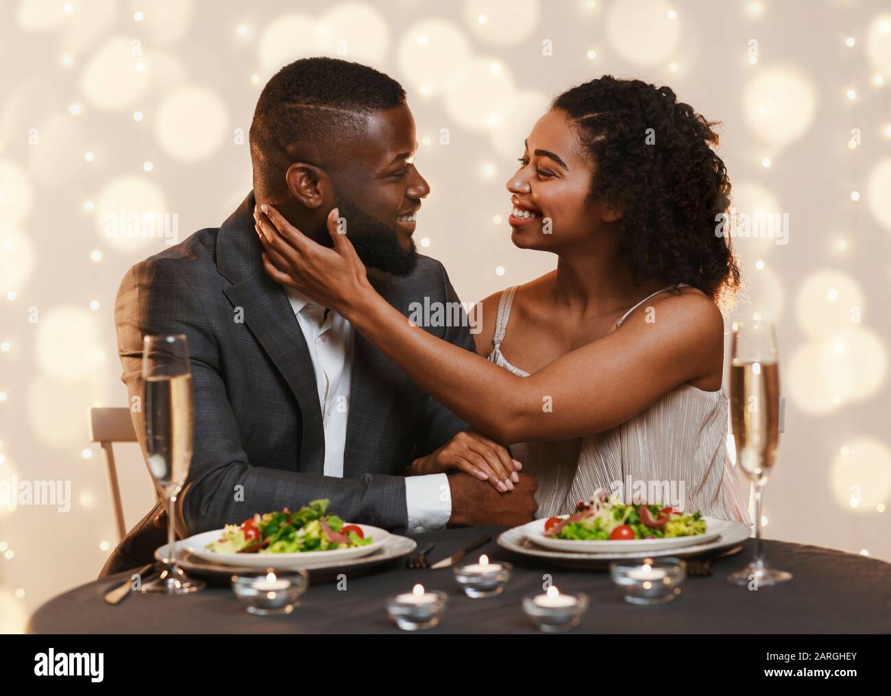 Attractive black woman touching her man, cuddling in restaurant Stock ...