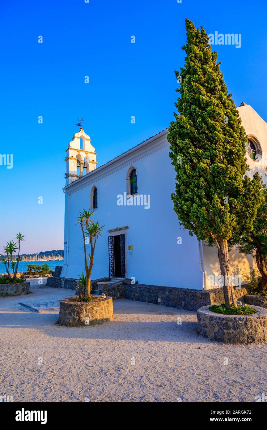 Ypapanti Church - Beautiful scenery at sunset in Gouvia Bay – small ancient white church on a ...