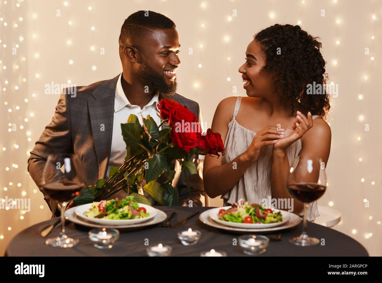 Afro guy in love giving roses to his surprised girlfriend Stock Photo ...