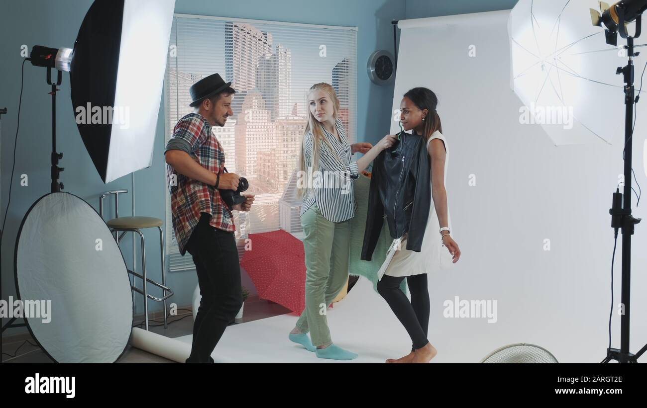 Backstage of the photo shoot: photographer with assistant choosing ...