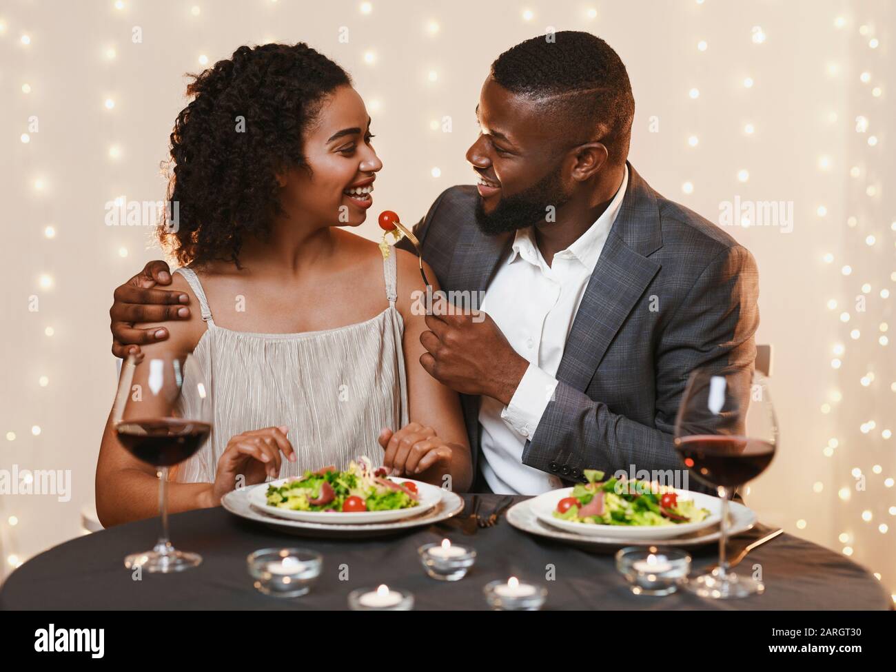 Couple in love feeding each other at restaurant Stock Photo - Alamy