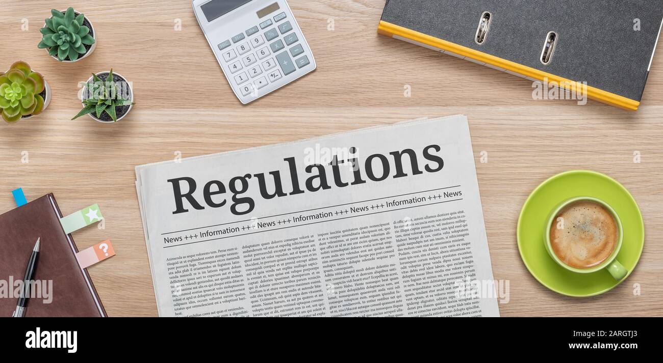 A newspaper on a desk with the headline Regulations Stock Photo - Alamy