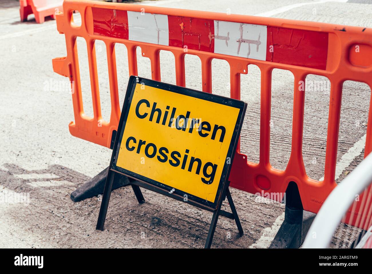 Yellow road traffic sign warning of children crossing Stock Photo - Alamy