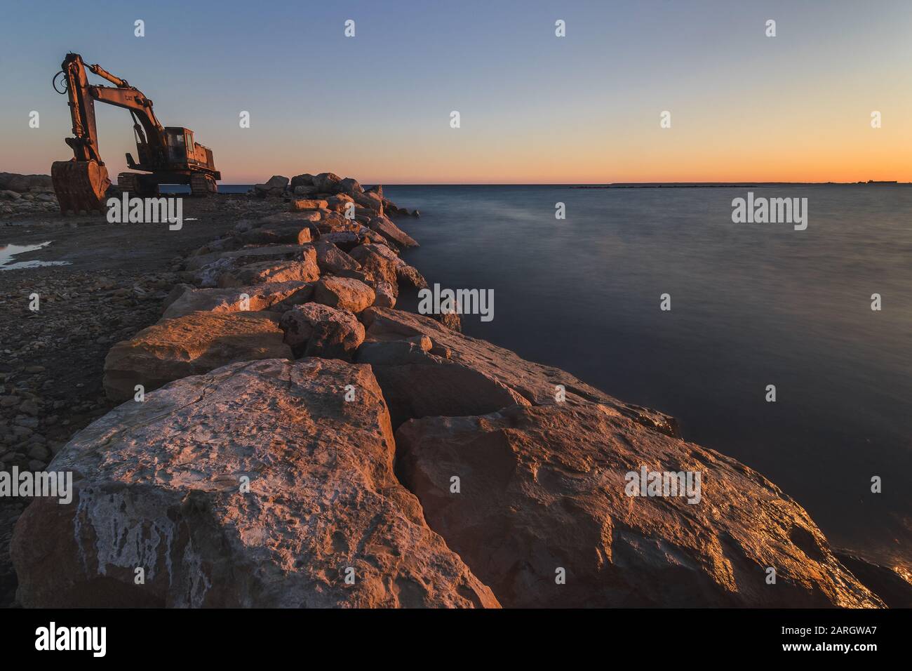 A large digger by the ocean Stock Photo - Alamy