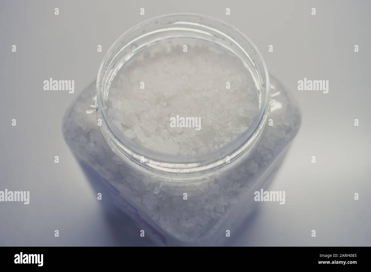 White sea salt in a plastic container close-up Stock Photo - Alamy