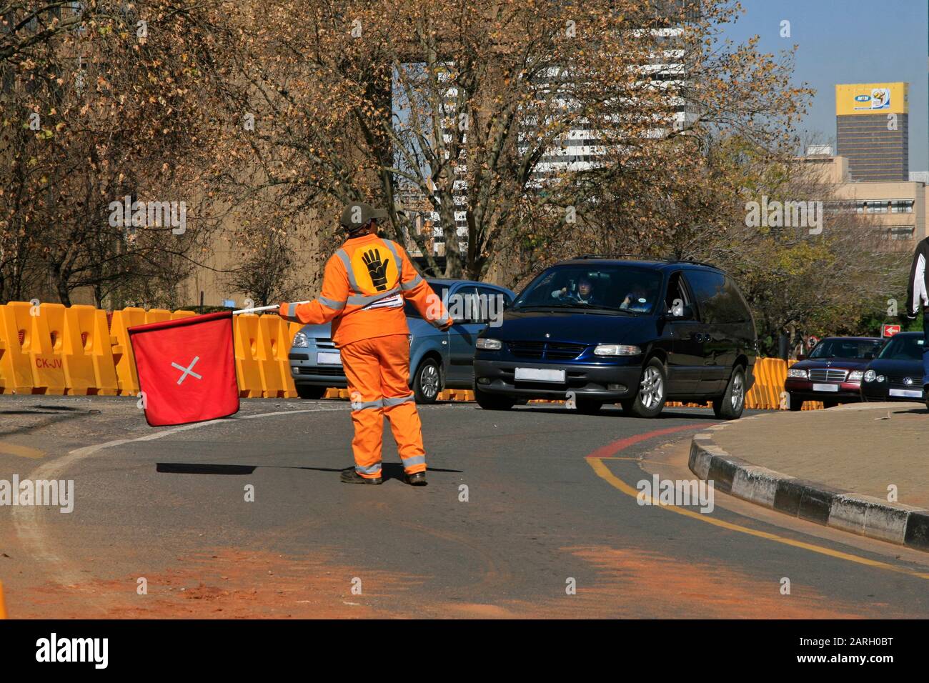Roadworks and road worker regulating traffic with road traffic safety ...