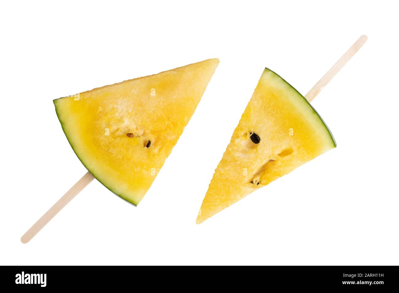 Triangular slices of yellow watermelon on wooden sticks isolated on a ...