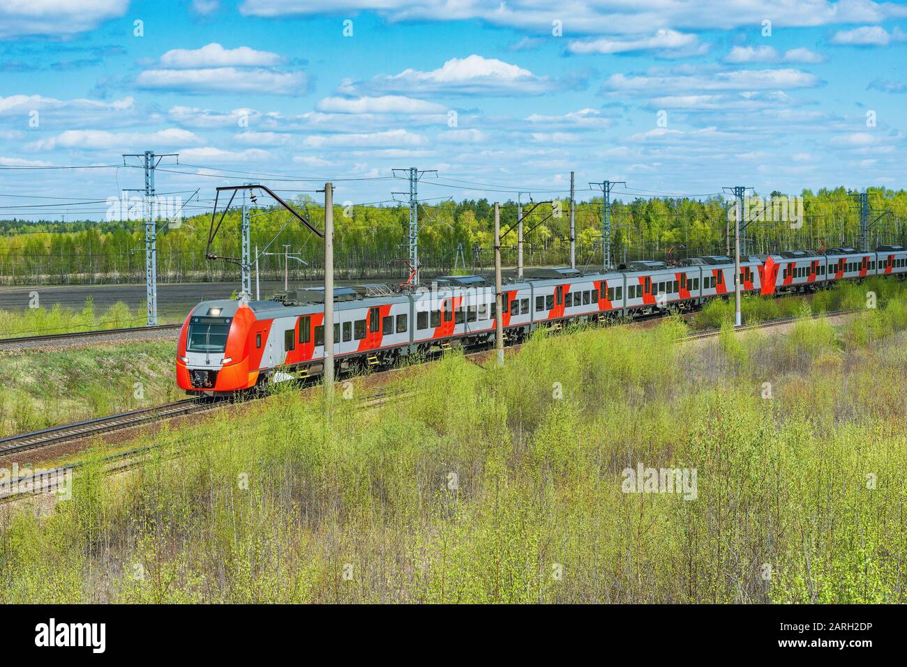 Modern high-speed train moves through the station at spring morning ...