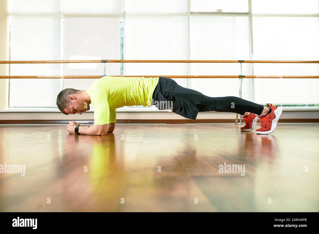 a man does an exercise plank in the hall on the floor opposite the ...