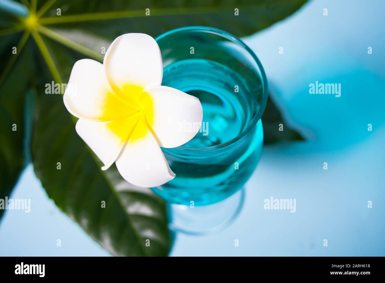 Exotic tropical Blue Curacao cocktail drink in a glass with Plumeria ...