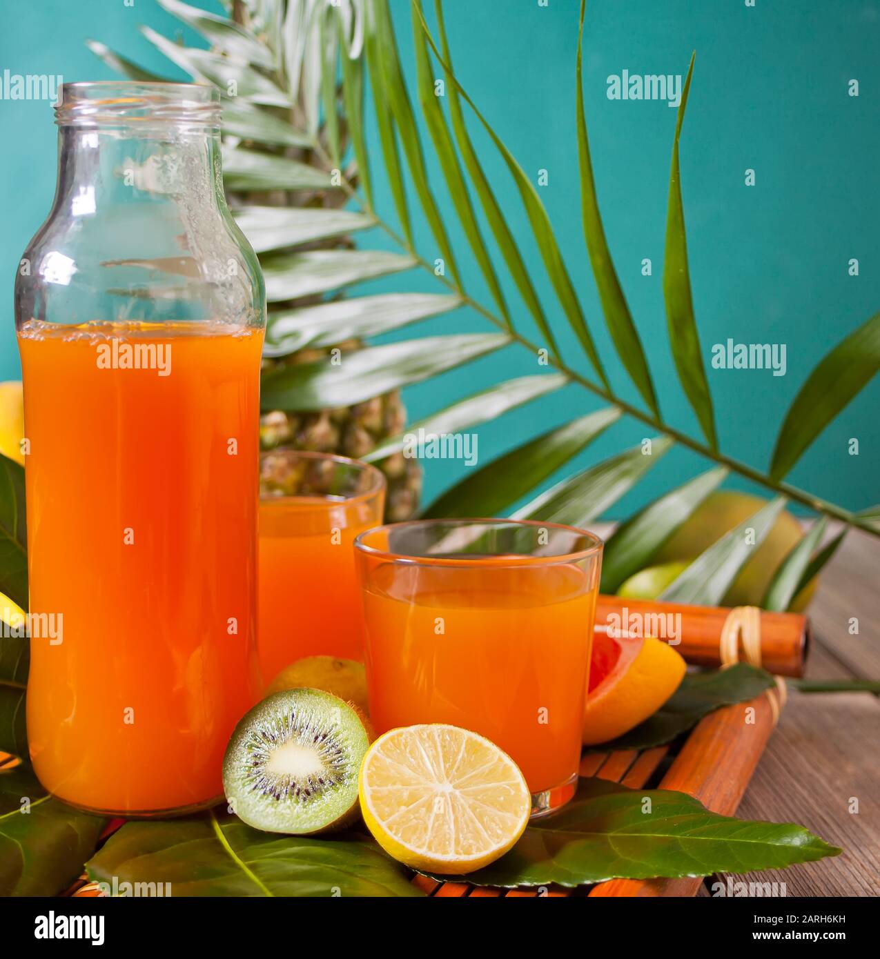 Two glasses and bottle of tropical exotic multifruit juice with ...
