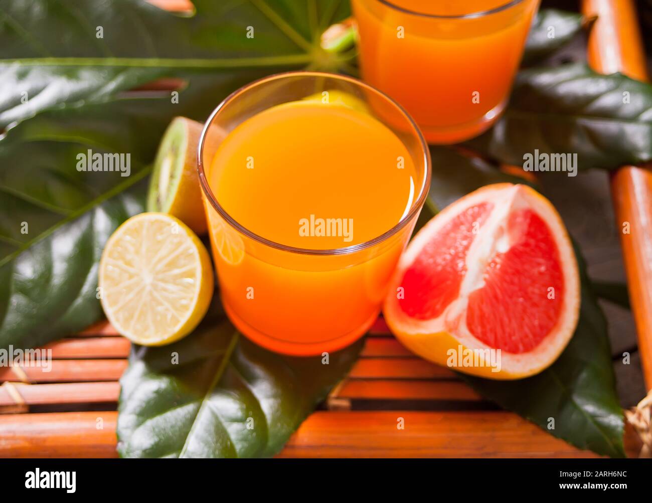 Two glasses of tropical exotic multifruit juice on a palm leaves Stock ...