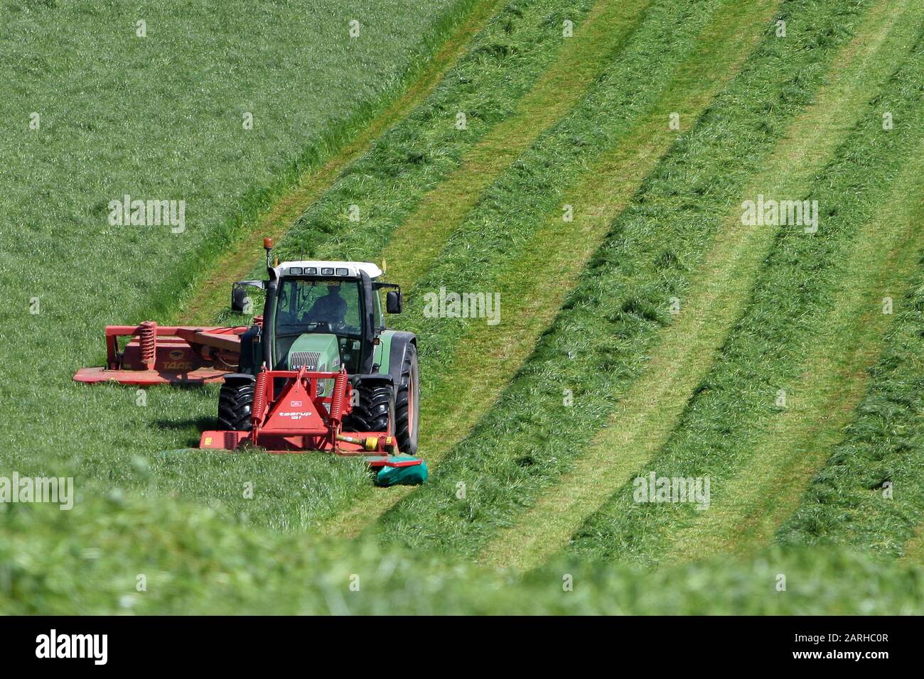 A Fendt tractor mowing a field near Dorchester in Dorset England Stock ...
