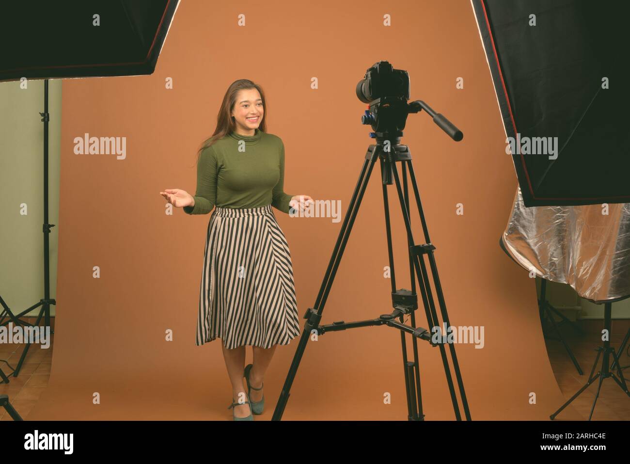 Young beautiful Indian woman vlogging against brown background Stock ...